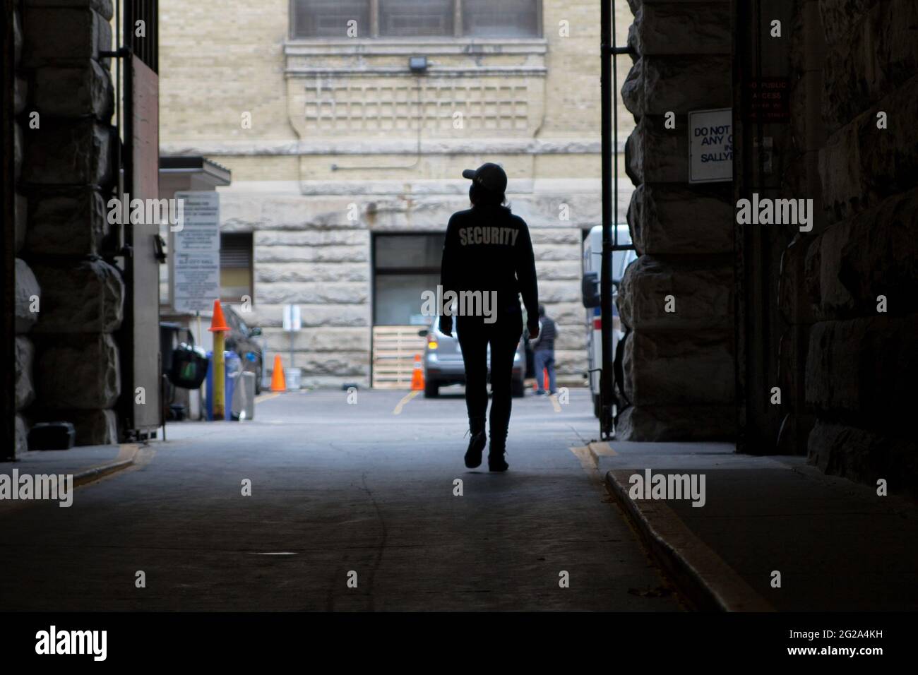Back view of a security guard in uniform patrolling a residential area ...
