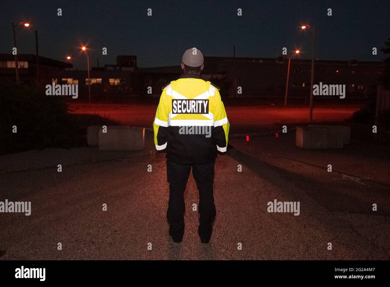 Back view of a security guard looking down the street in the dark Stock ...