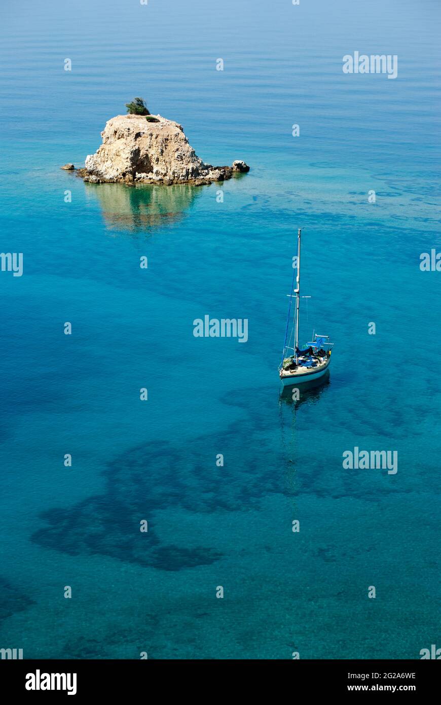 Aerial view of a sailing boat in transparent water of sea with a small ...