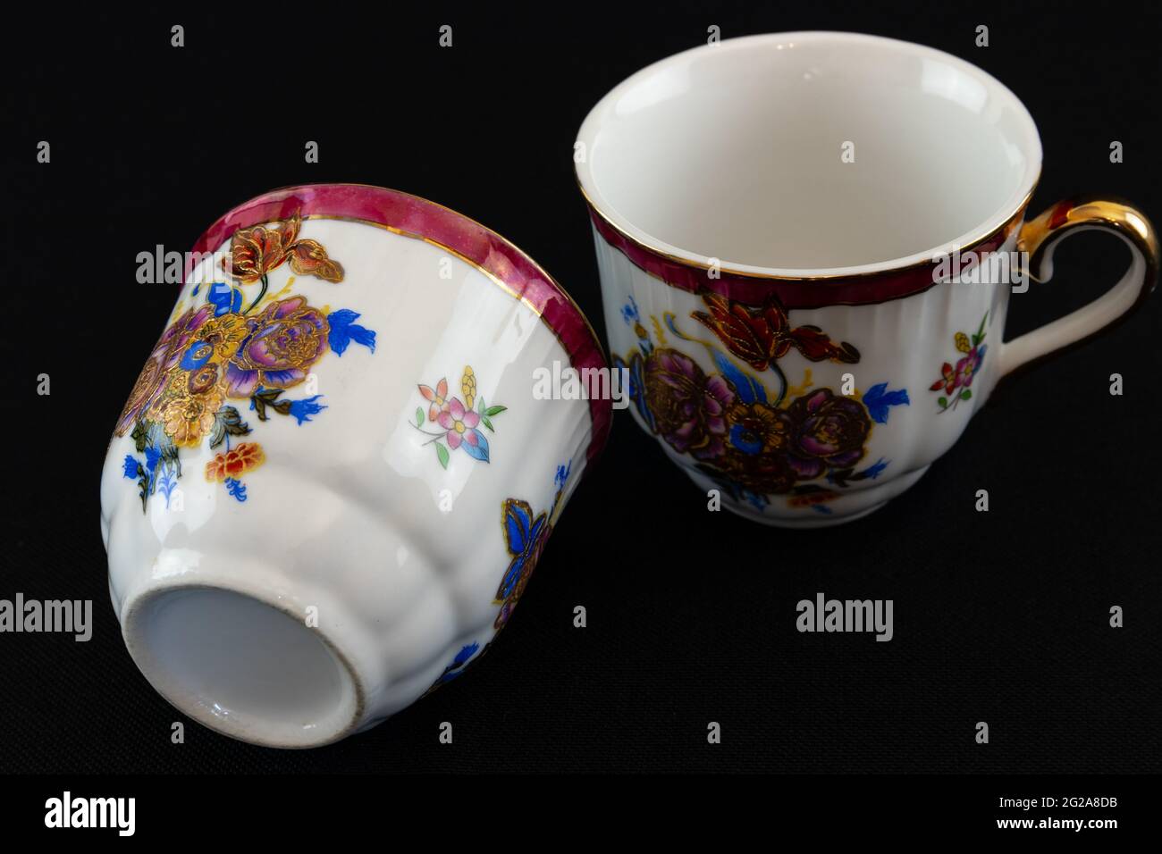 Closeup shot of vintage ceramic cups isolated on a black background ...