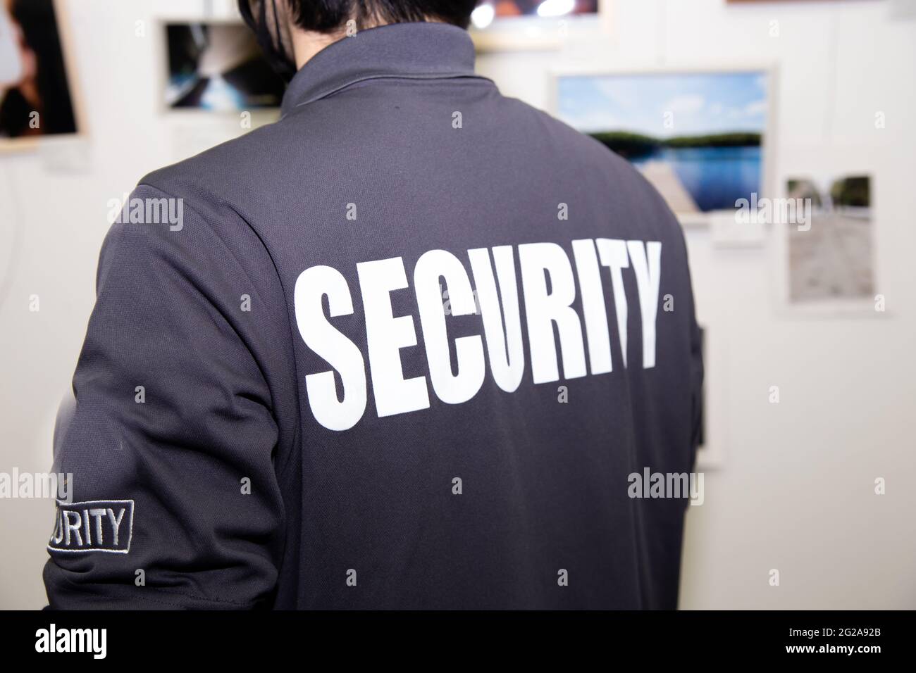 Rear view of a security guard in uniform patrolling in a commercial ...