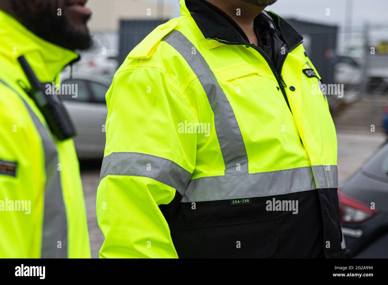 Security in uniforms watching over the parking area Stock Photo - Alamy