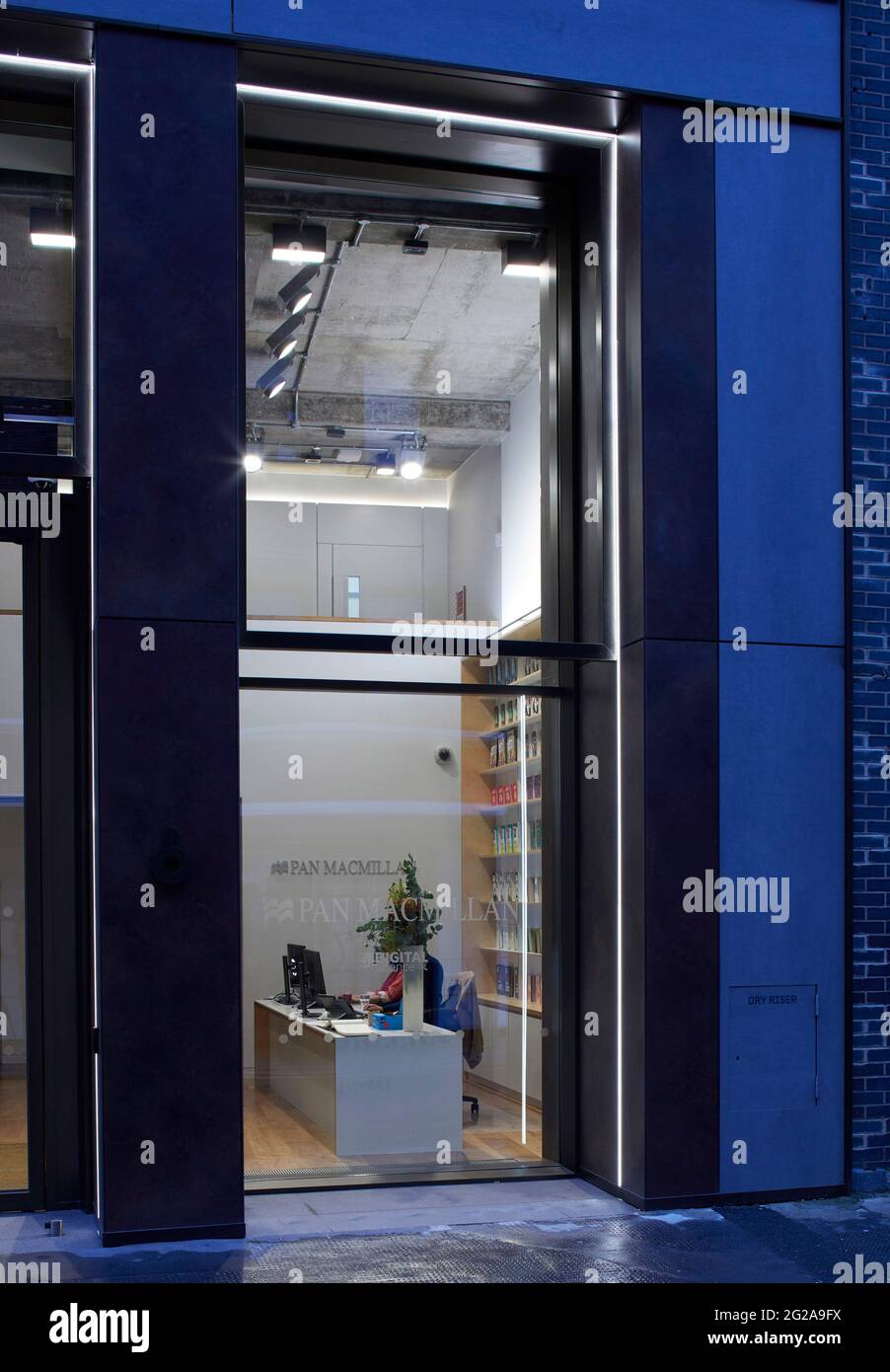 Exterior view of reception desk at dusk. Pan Macmillan offices, London ...