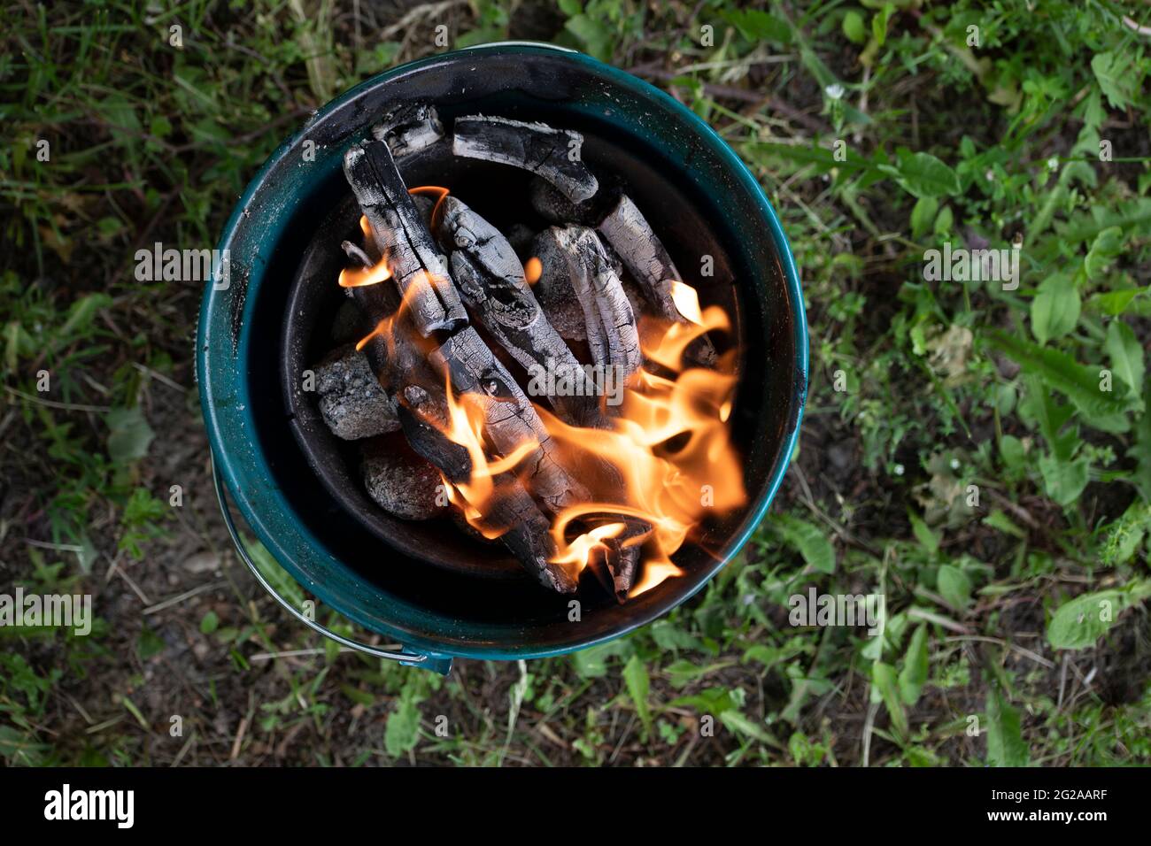 Firing a barbecue in the home garden. Flames floating above charcoal ...