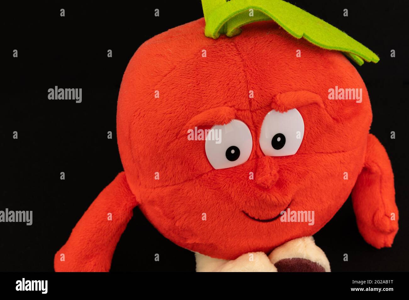 Tomato-shaped toy isolated on a black background Stock Photo - Alamy