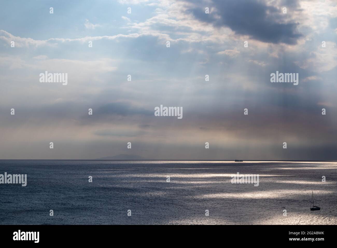 Sun rays shining though clouds over the sea in Greece. Dramatic ...