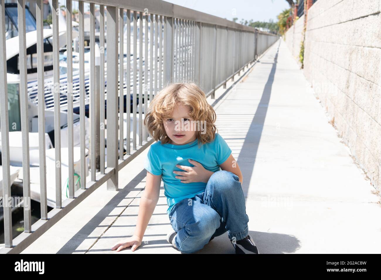 Paused for breath. Boy relax hunkering down on promenade. Boy child ...