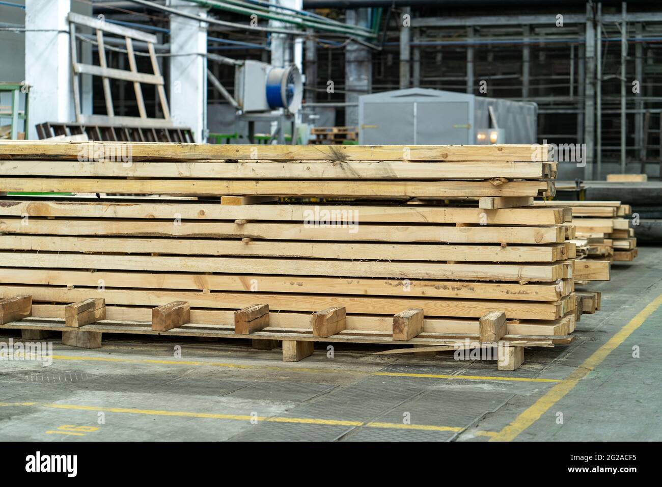 Stack of wooden boards in woodworking factory. Timber for construction ...