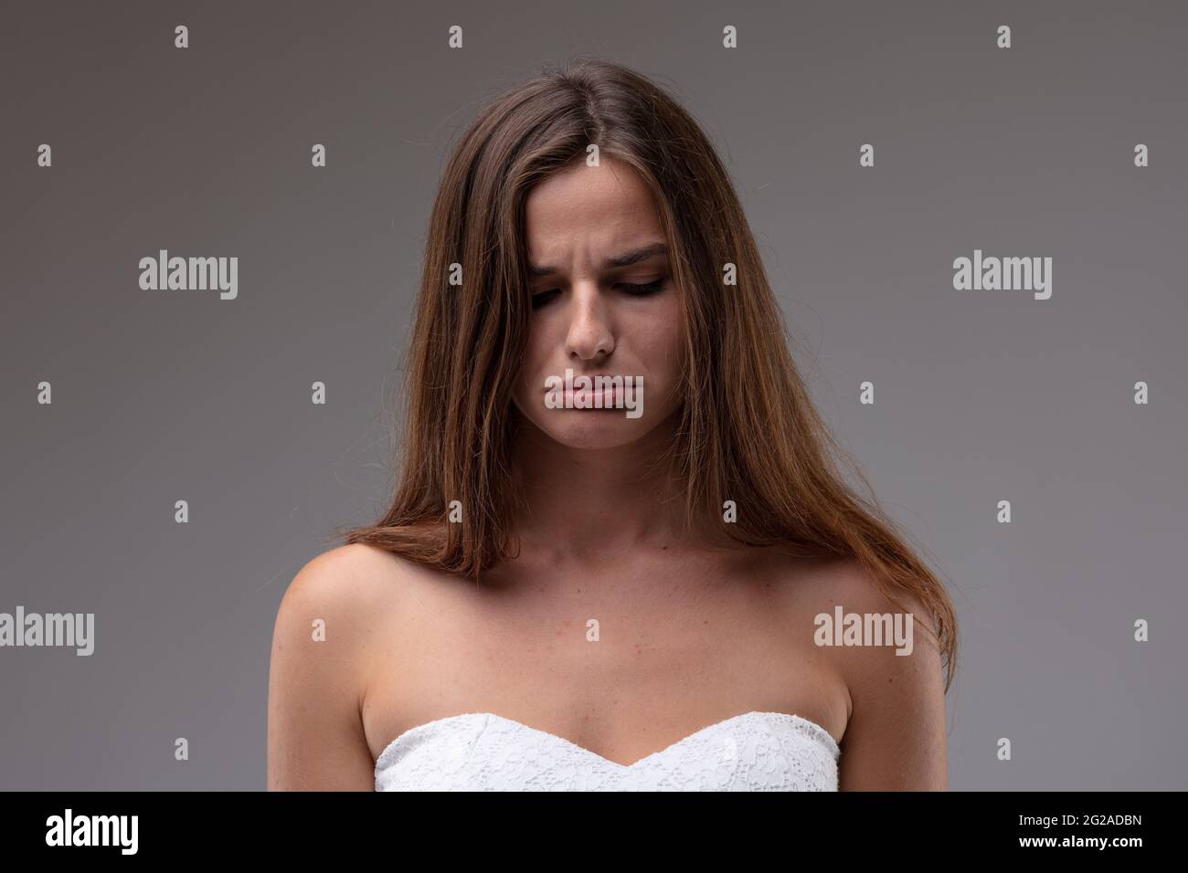 Sulky petulant attractive young woman scowling and pouting her lips in ...