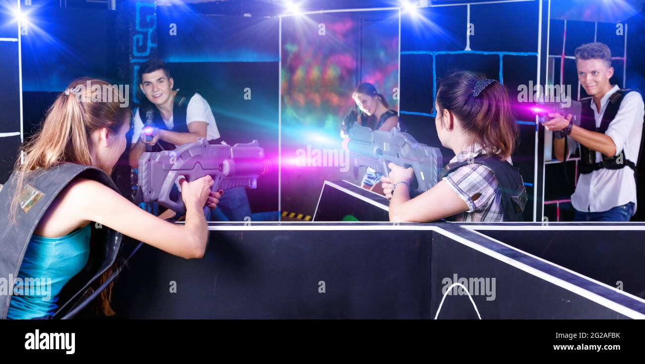 Two laser tag teams playing enthusiastically and aiming at each Stock ...