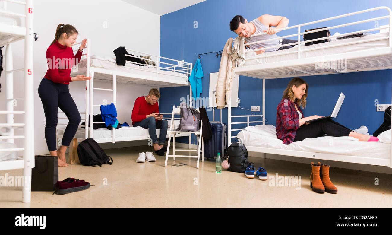 Young men and women friendly interacting while staying in modern comfy ...