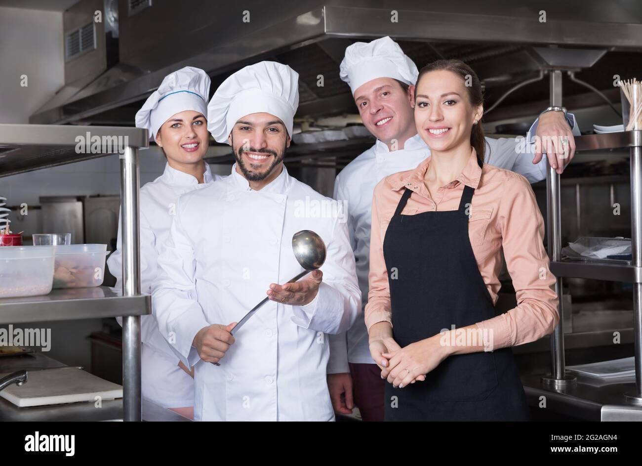 Team of restaurant staff posing together at modern professional kitchen ...