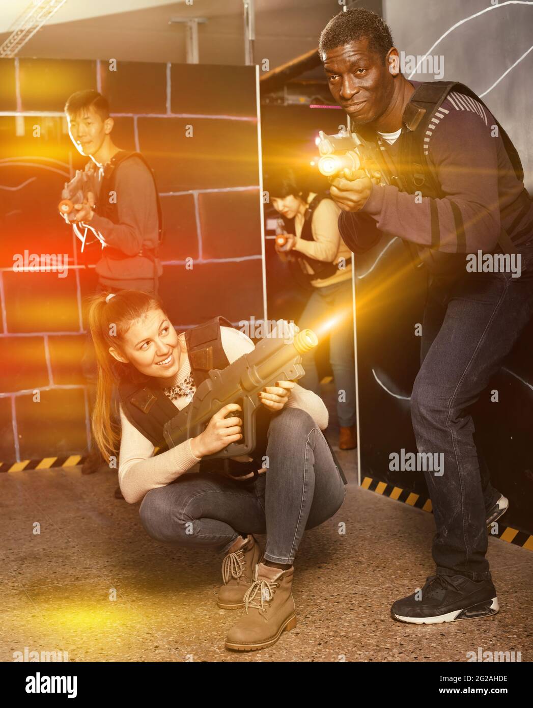 Young man and woman playing laser tag Stock Photo - Alamy
