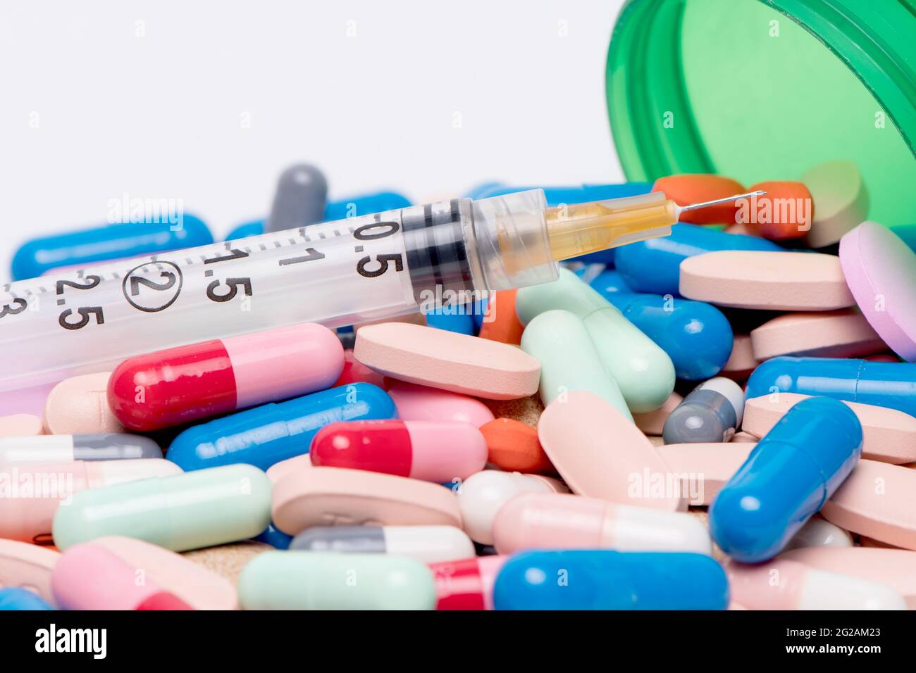 Medical pills and tablets spilling out of a drug bottle with syringe ...