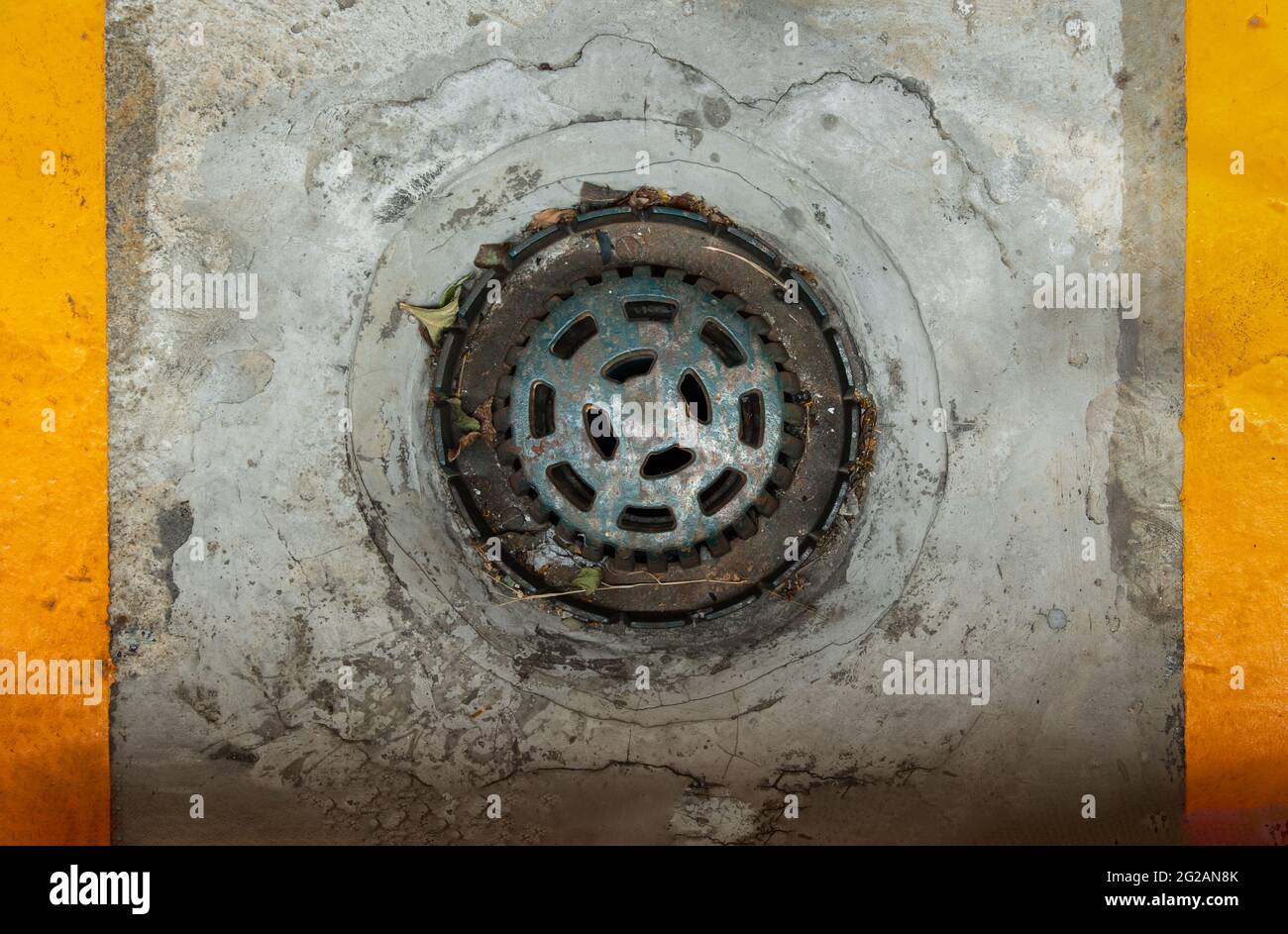 Old steel round storm drain grate on the main hole drains the water. A ...
