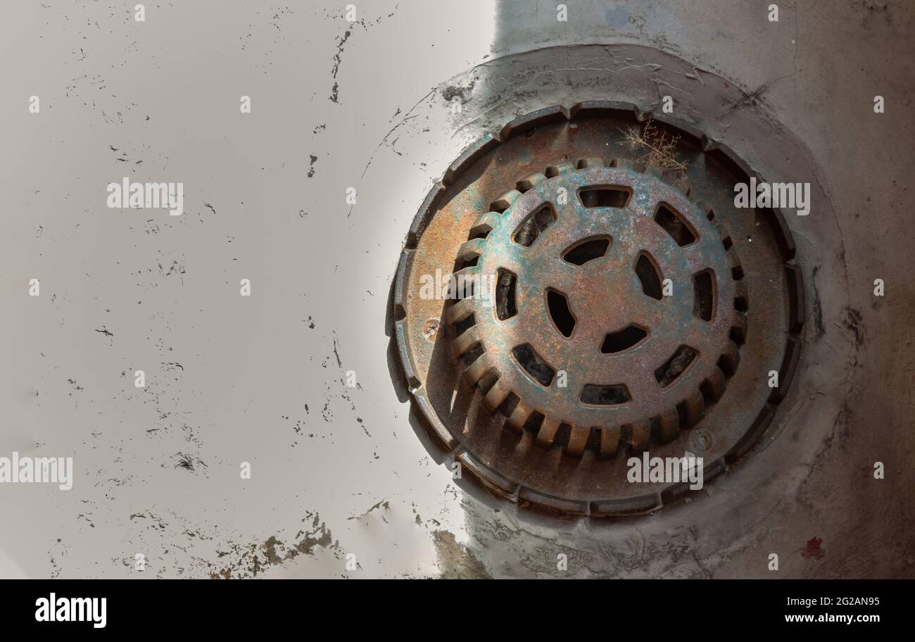 Old steel round storm drain grate on the main hole drains the water. A ...