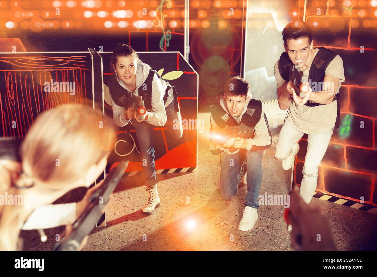 Group of young people playing laser tag game with laser guns Stock ...