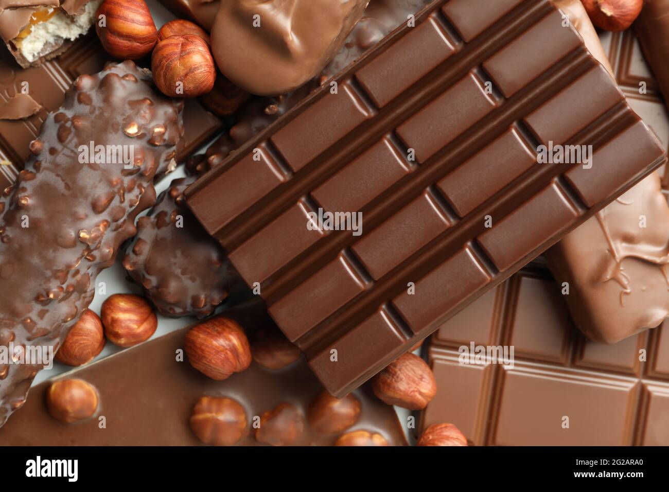 Different tasty candy bars and nuts, close up Stock Photo - Alamy