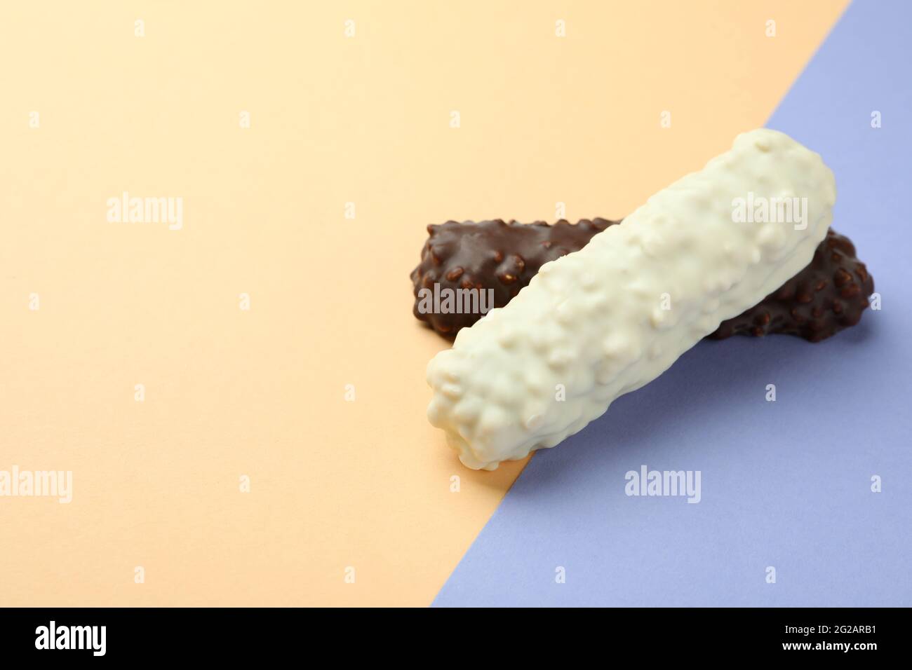 Tasty candy bars on two tone background Stock Photo - Alamy