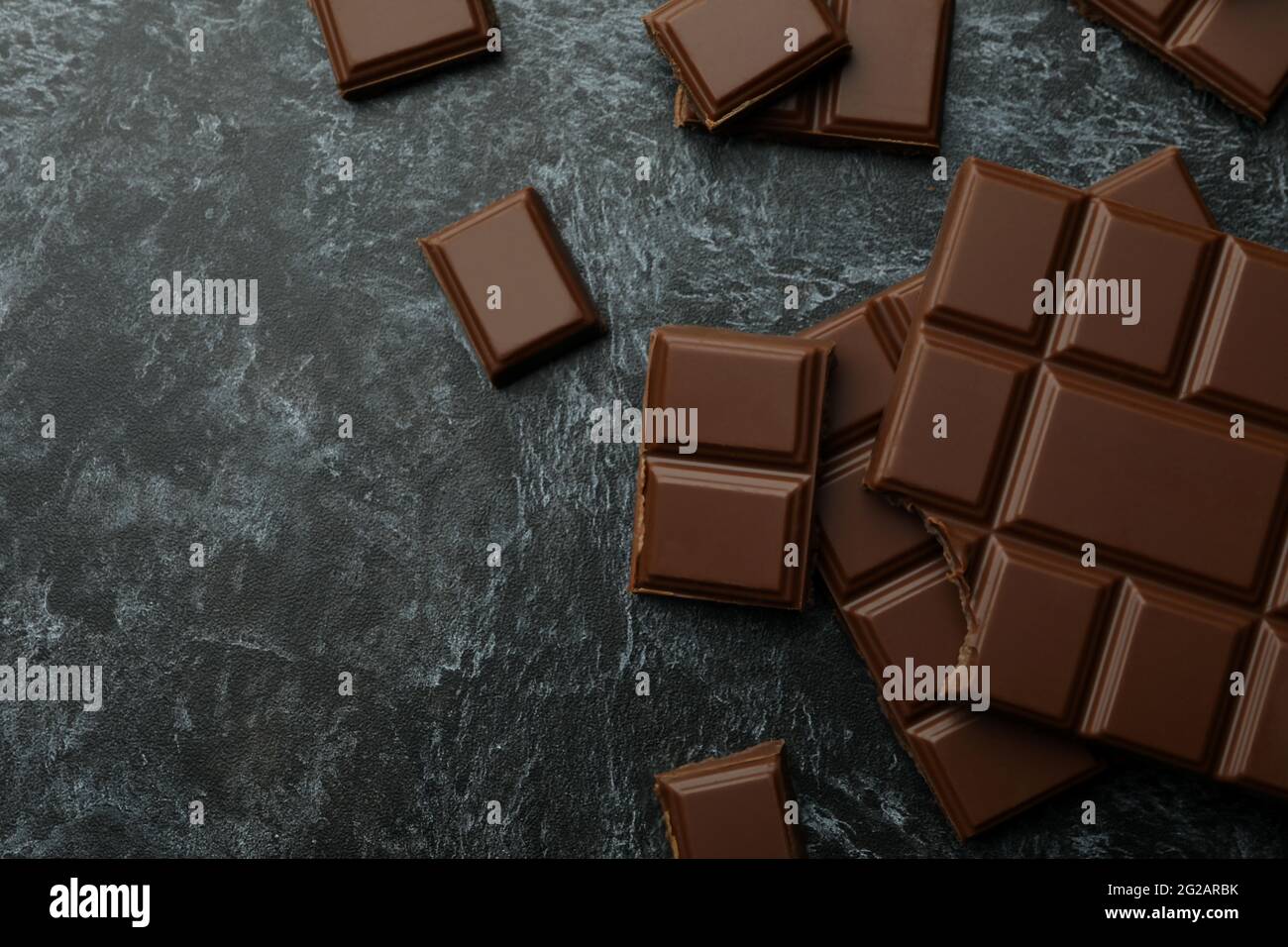 Tasty chocolate bars on black smokey background Stock Photo - Alamy