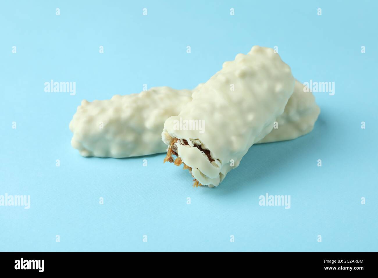 Tasty white candy bars on blue background Stock Photo - Alamy