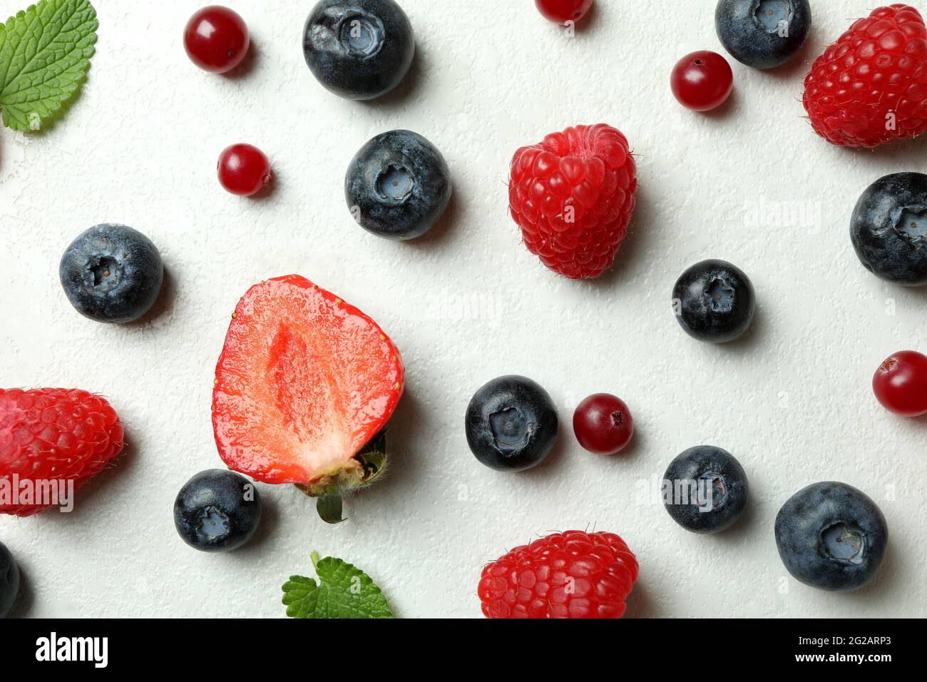 Delicious fresh berry mix on white textured background Stock Photo - Alamy
