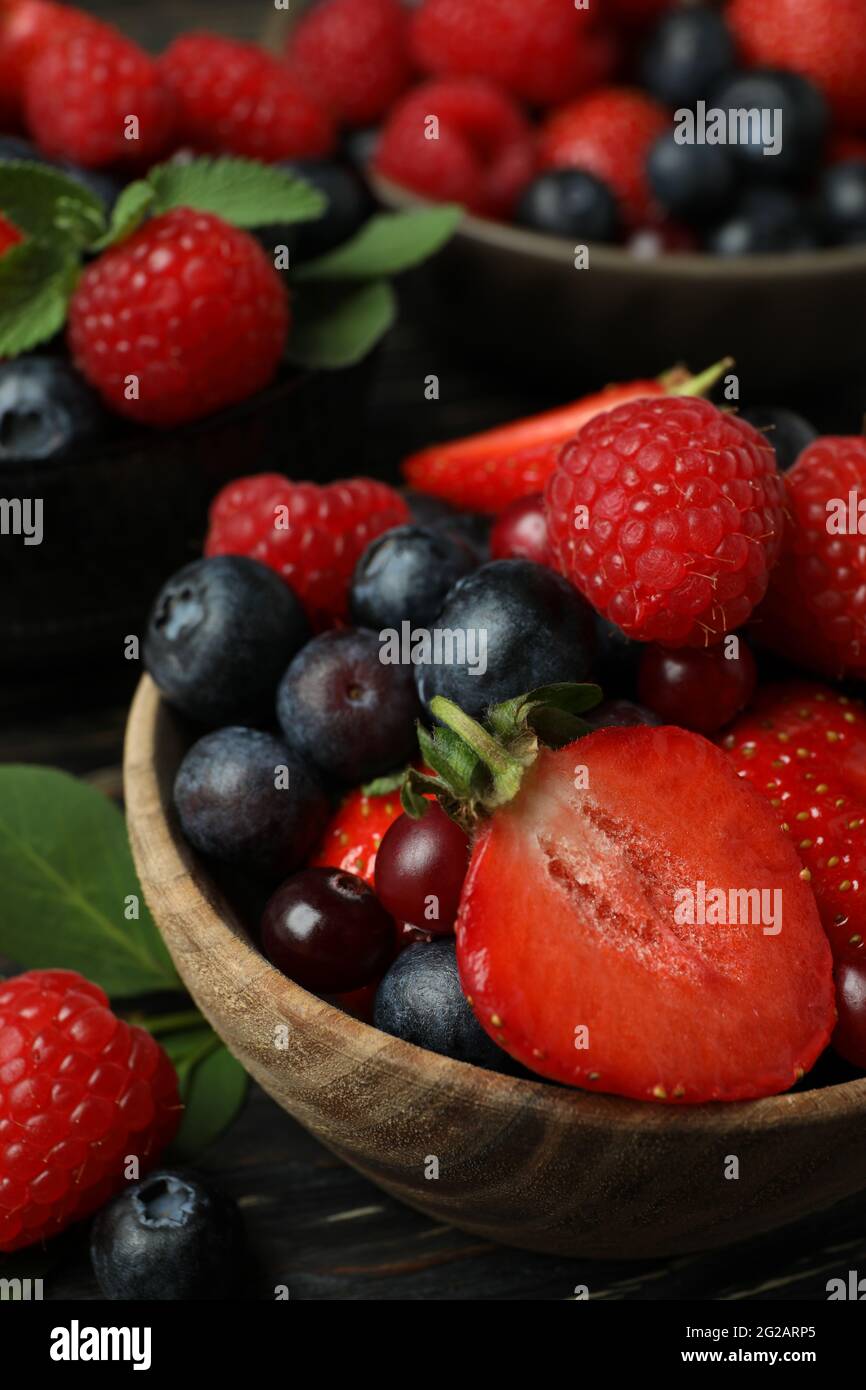 Bowls with berry mix on wooden table Stock Photo - Alamy