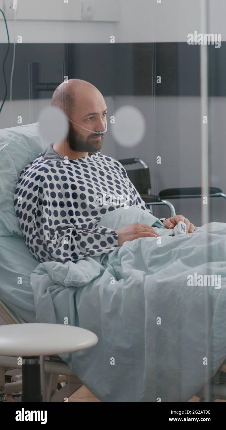 Stressed sick man sitting in bed waiting for respiratory treatment ...