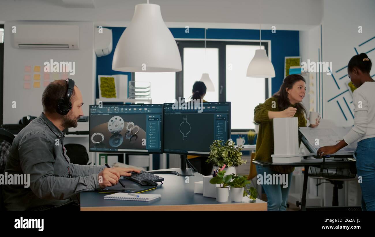 Industrial designer with headset working on PC, screen showing CAD ...