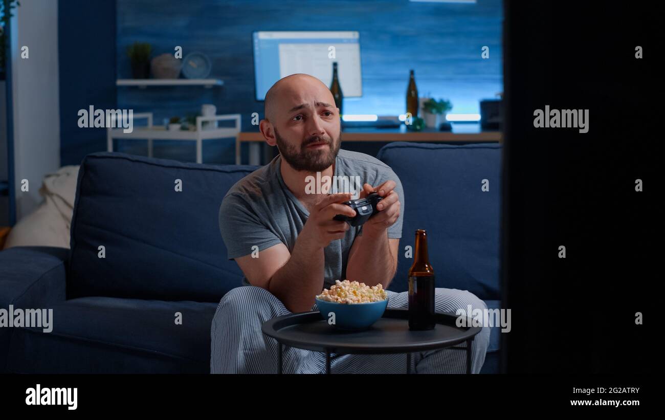 Angry disappointed man losing video game playing with joystick ...