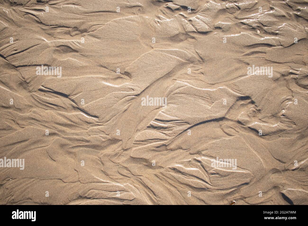 Wavy lines in the sand at beach, made by the ocean, during summer ...