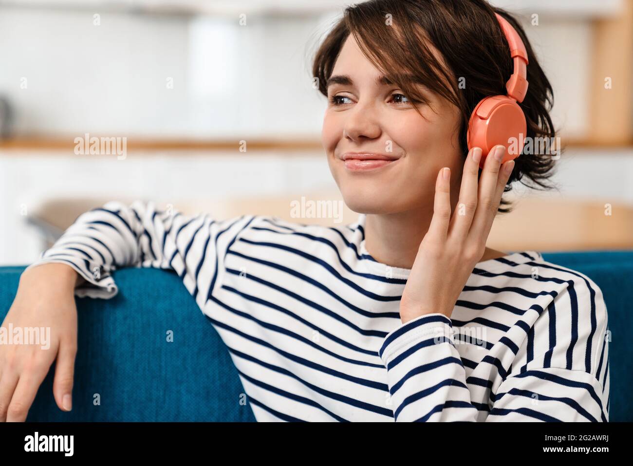 Happy beautiful girl smiling while listening music with headphones on ...