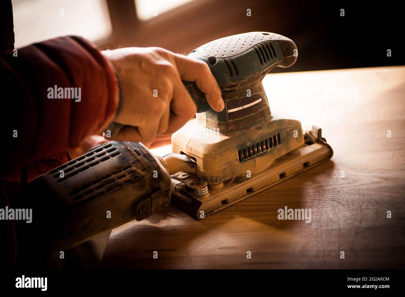 Man sanding wood plank using electric sand machine Stock Photo - Alamy