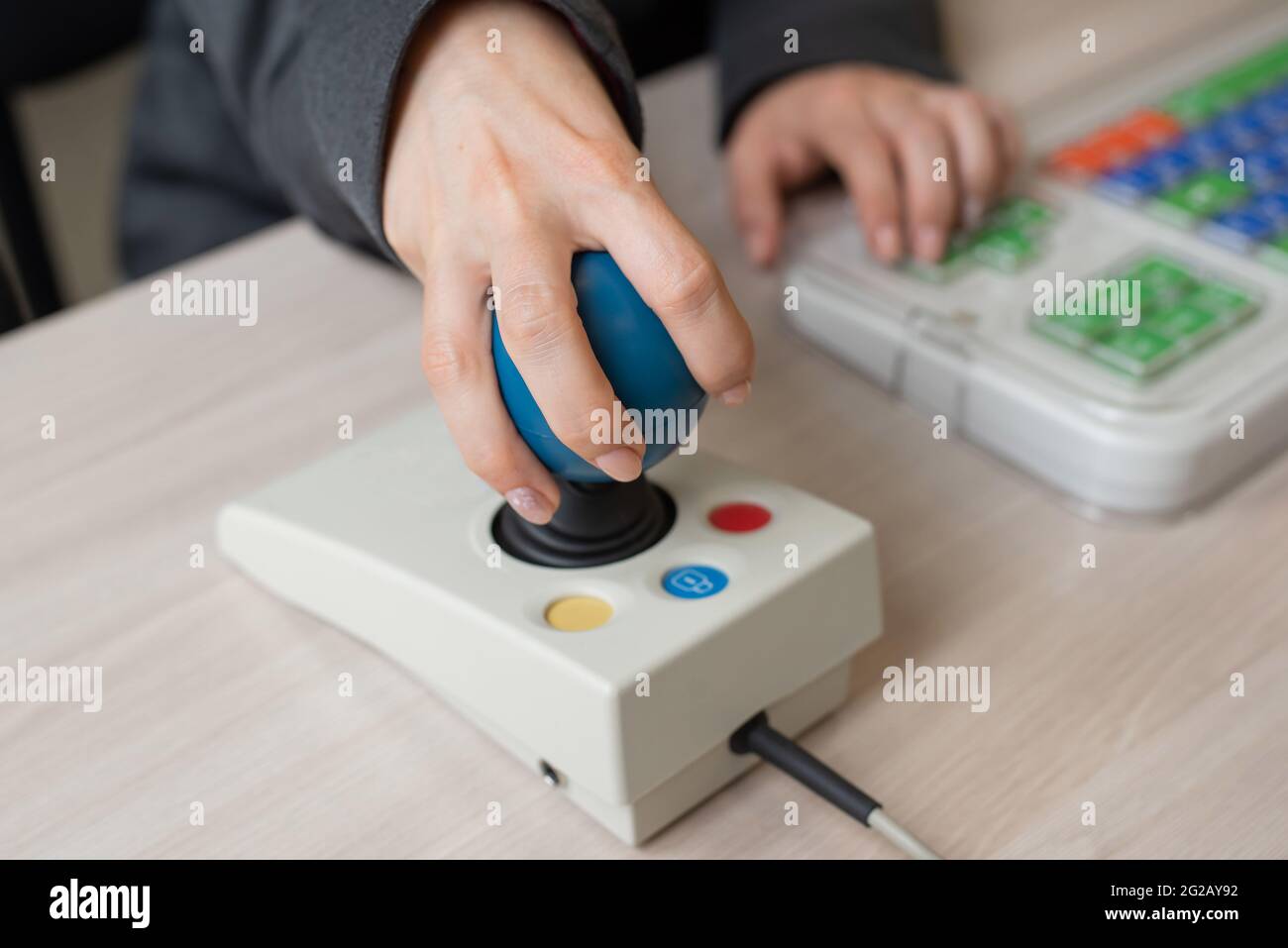 An unrecognizable woman with cerebral palsy is typing on the keyboard ...
