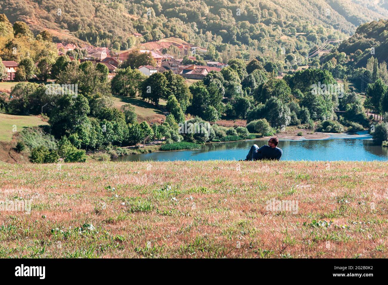 Man lying in the meadow resting on the route linking the villages of ...