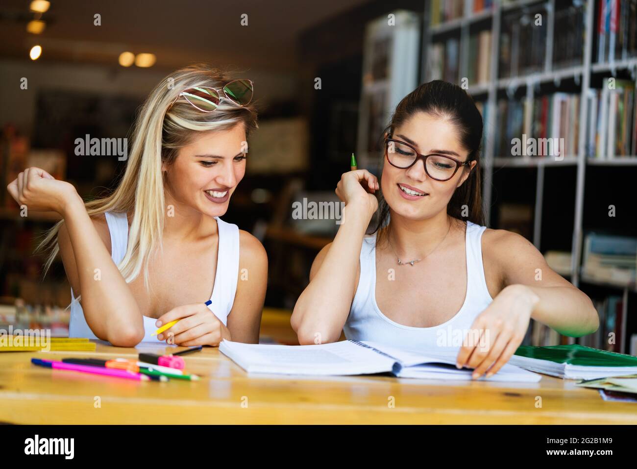 Happy young university students friends studying with books at ...