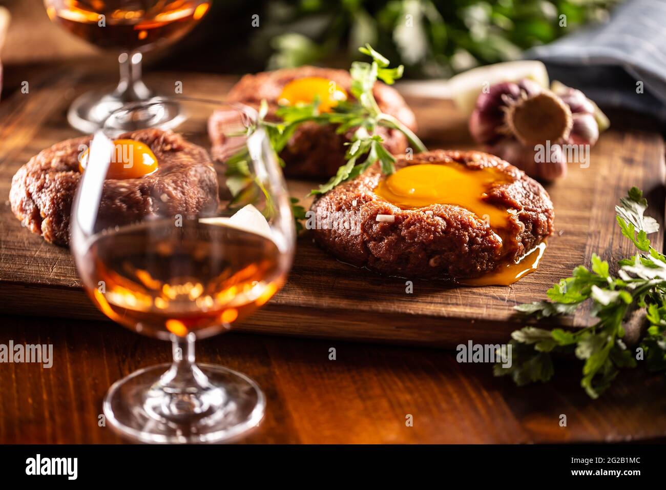 Savory beef steak tartare served with egg yolk, garlic and herbs on a ...