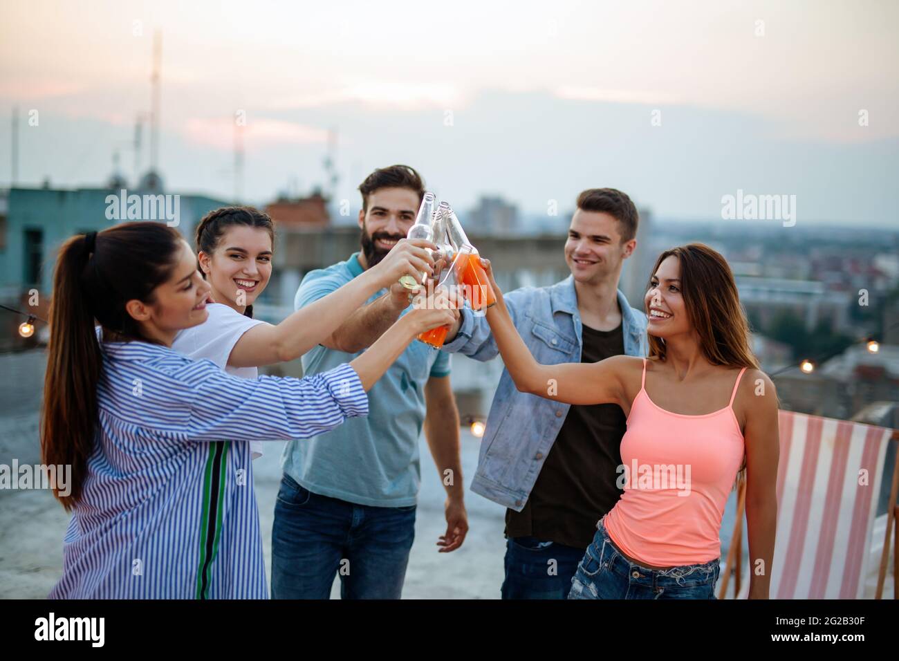 Happy friends toasting with drinks at a rooftop party Stock Photo - Alamy