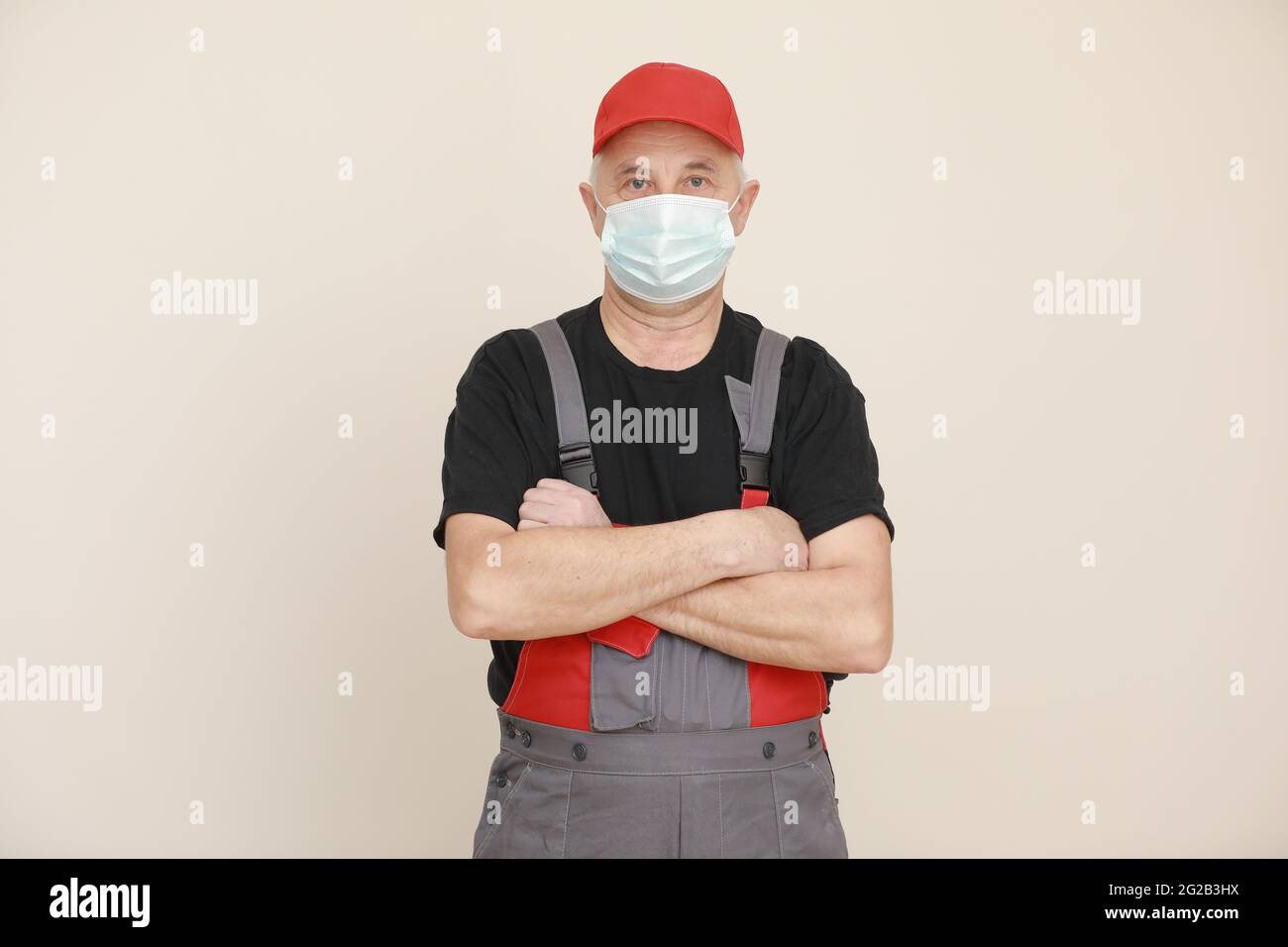 Work are done. Portrait of worker man with medical mask in red overall ...