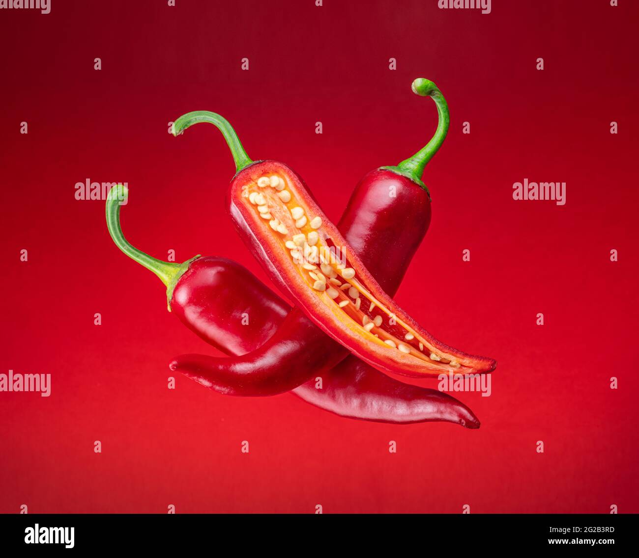 Fresh red chilli peppers and cross sections of chilli pepper with seeds ...