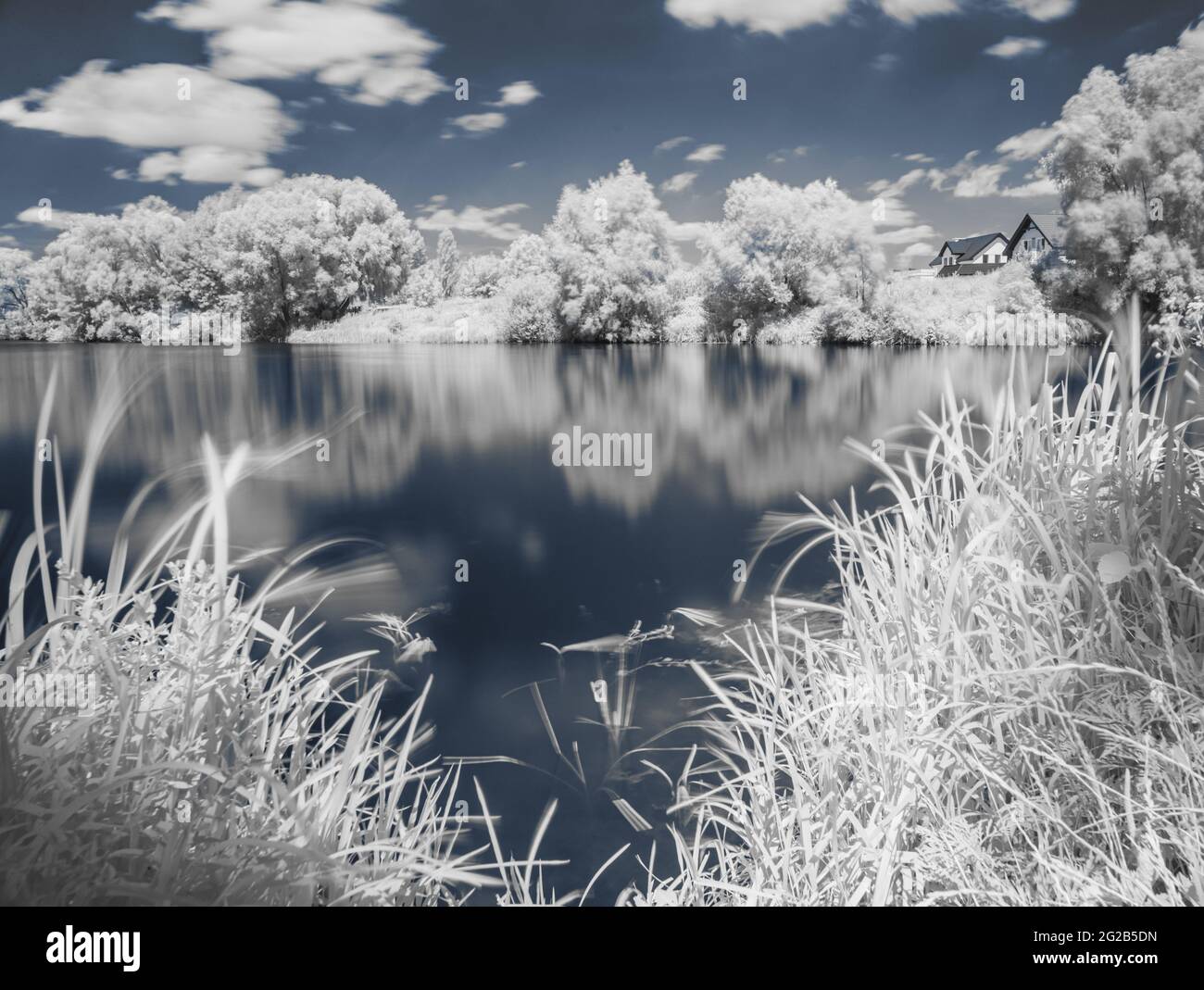 Near infrared photography of beautiful summer river bank and cloudy sky ...
