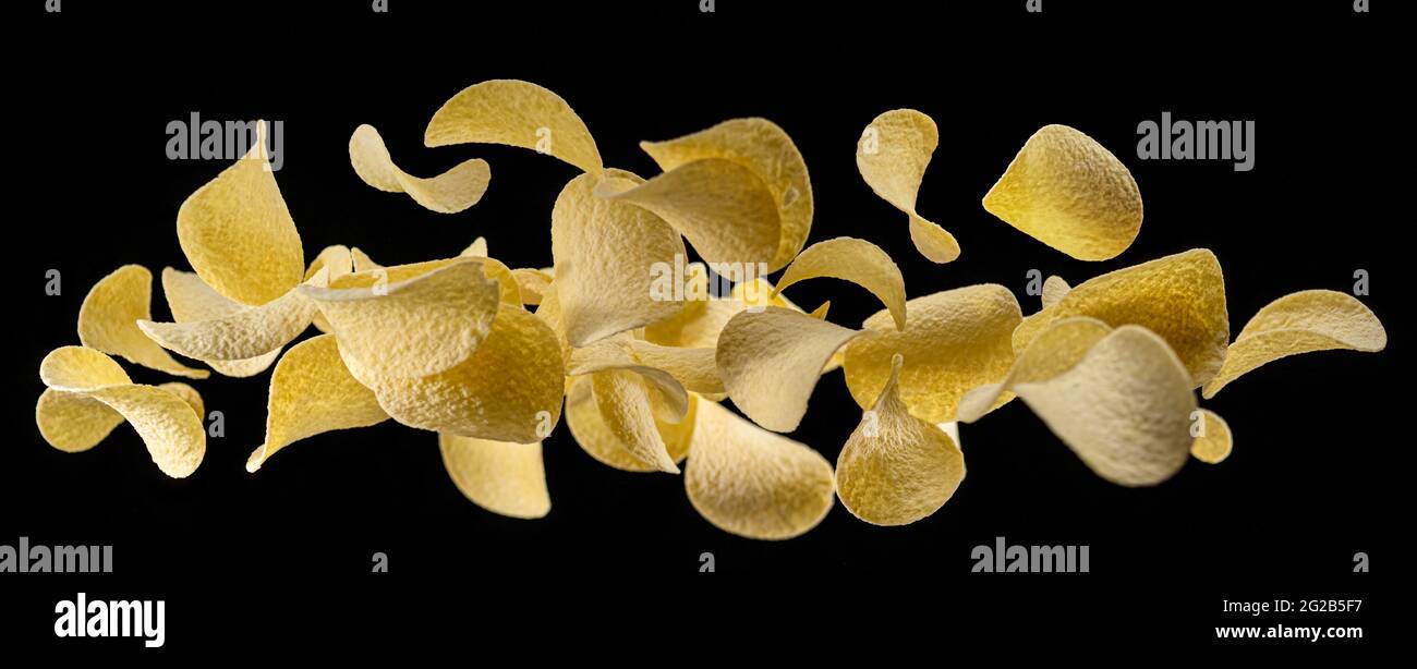 Delicious potato chips floating in the air. Black background. Fast food ...