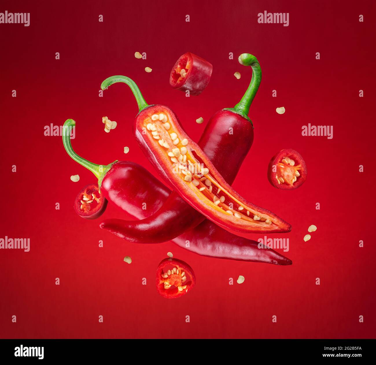 Fresh red chilli peppers and cross sections of chilli pepper with seeds ...