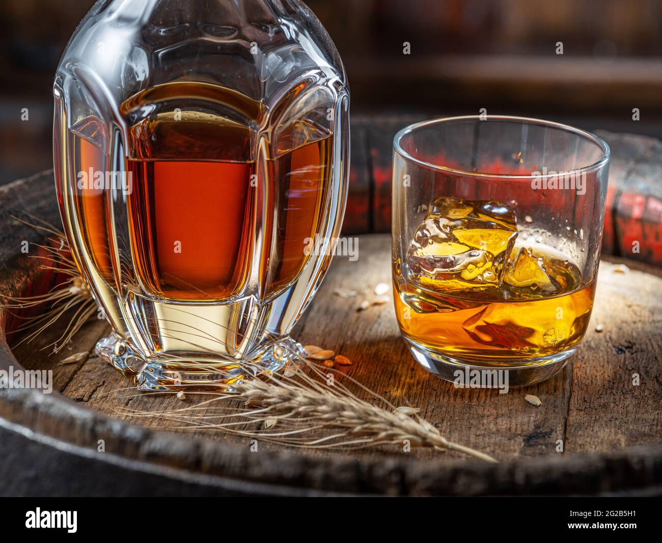 Carafe of whisky and glass of whisky on old wooden cask at the dark ...