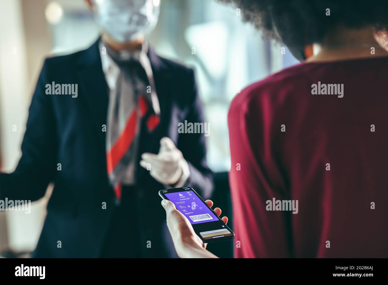 Woman holding mobile phone with flight ticket details at airport check ...