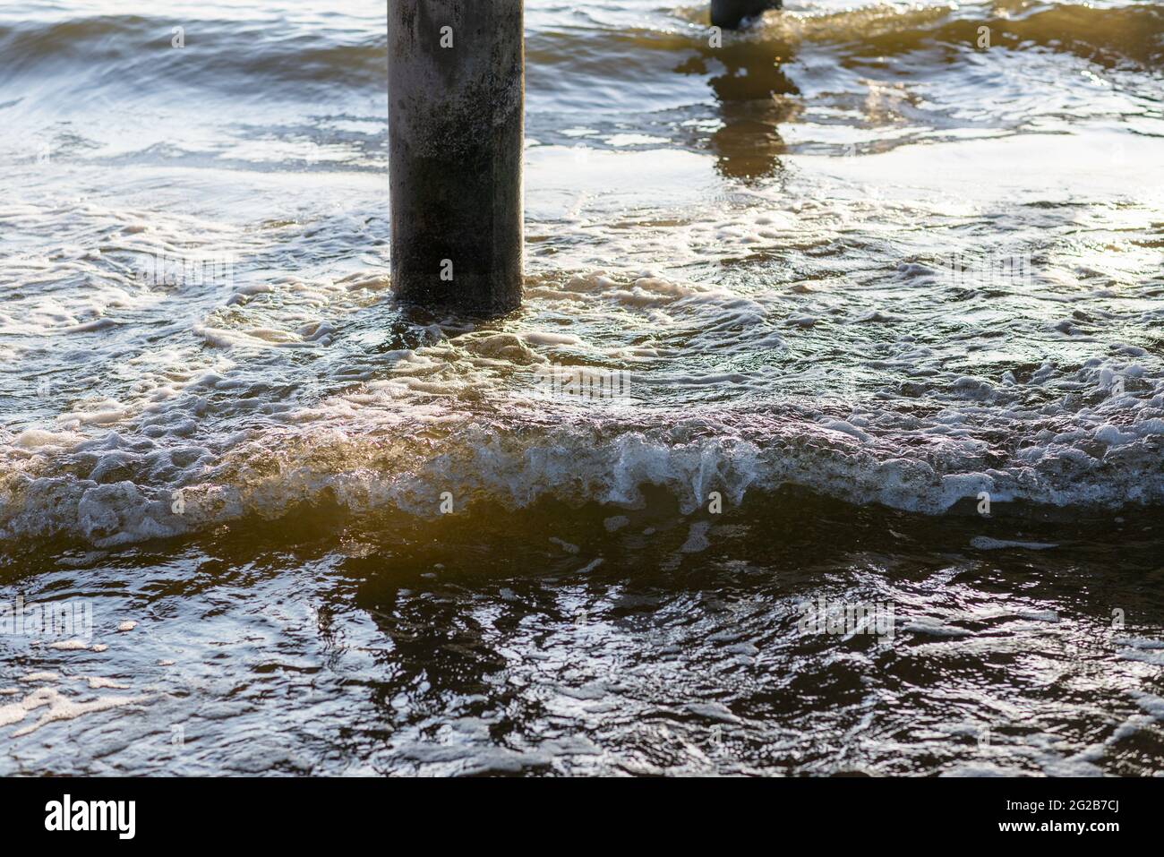 Columnar bridge piers at sunset.View under the bridge into sea with ...