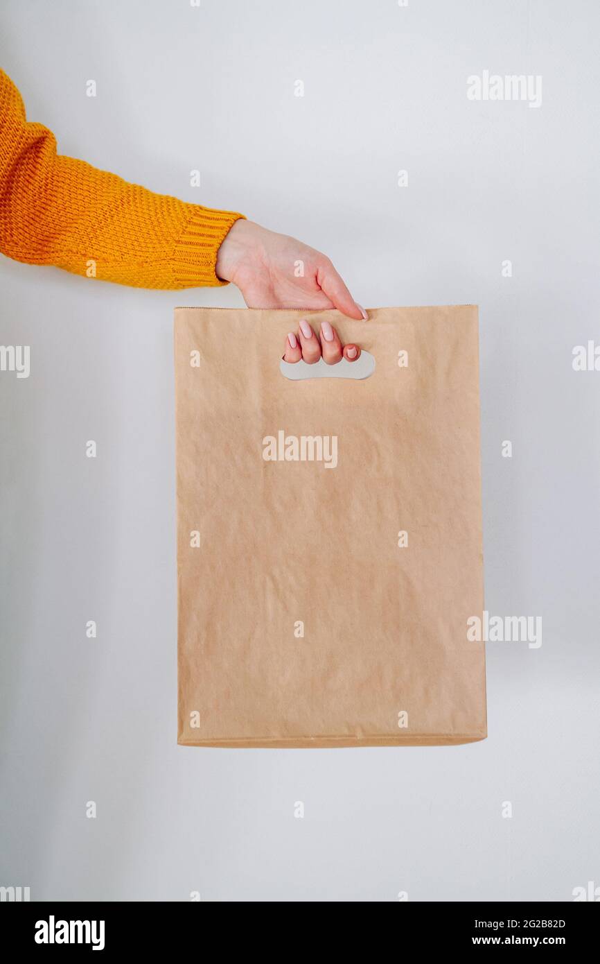 Female delivery hand with paper shopping bag Stock Photo - Alamy
