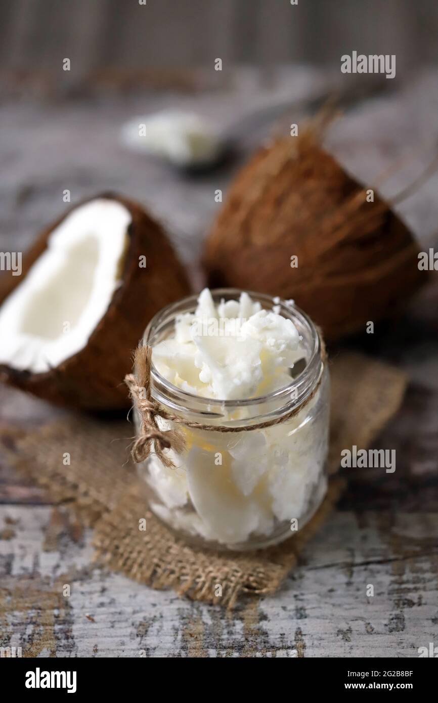 Coconut oil in a jar. Coconut halves Stock Photo - Alamy