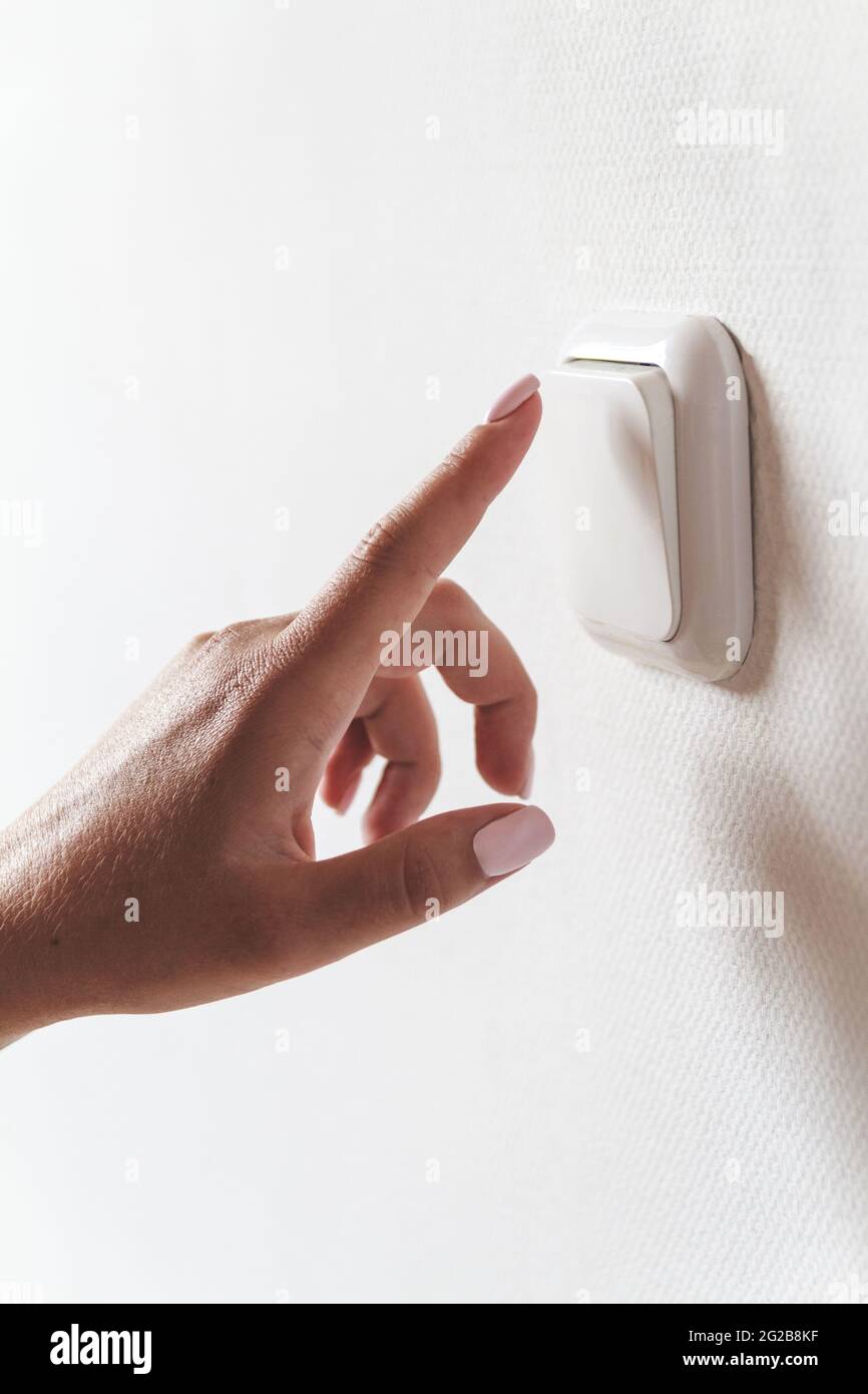 Female hand turns off the light indoors. Electrical energy savin Stock ...