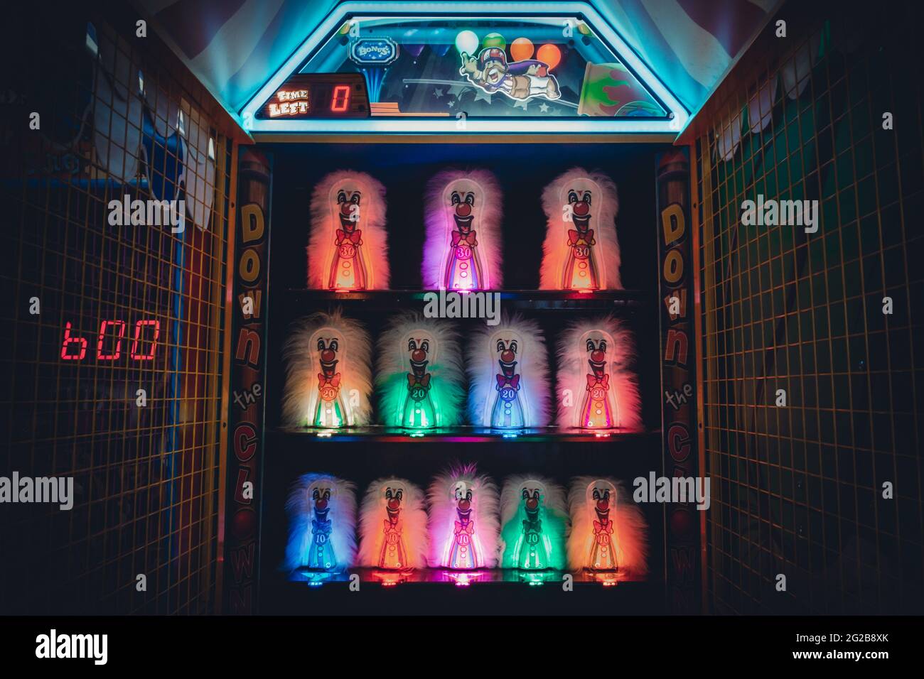 A lighted Down The Clown game in a darkened arcade Stock Photo - Alamy